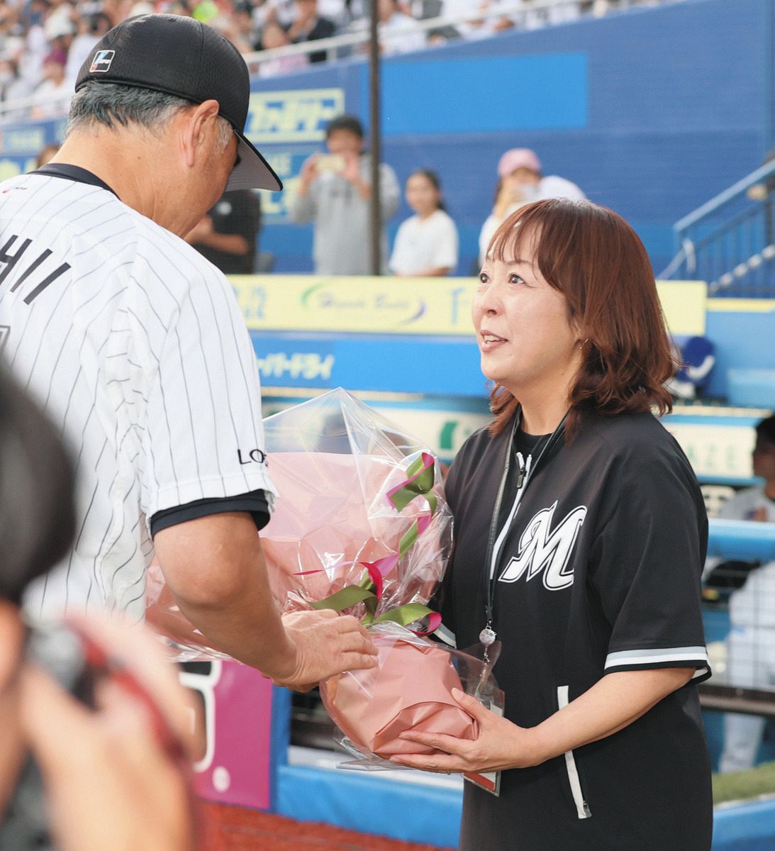 ロッテ・吉井監督から花束を贈られる谷保恵美さん【写真】：中日スポーツ・東京中日スポーツ